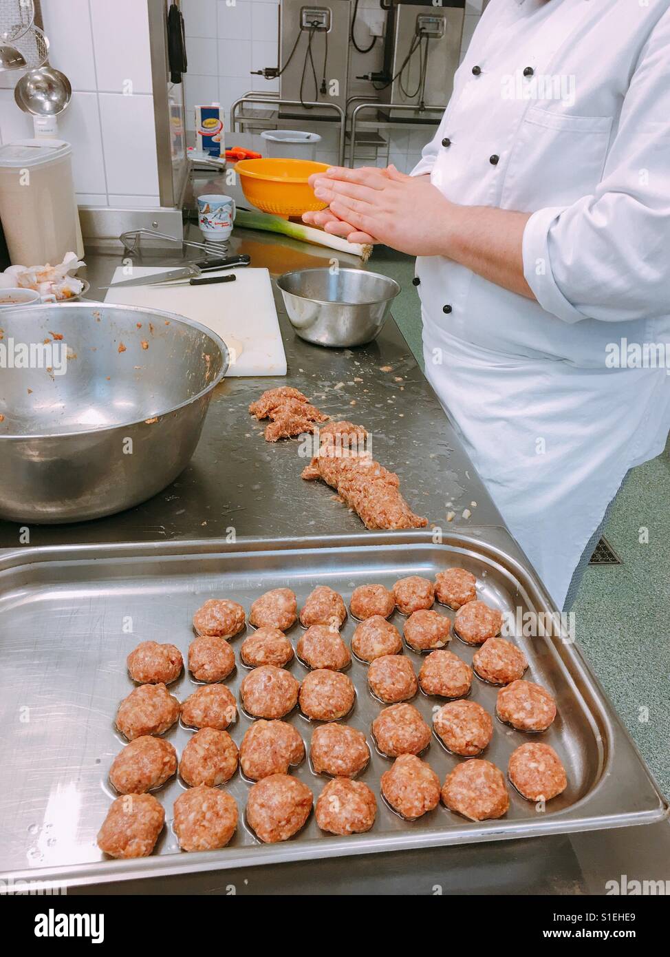 A young trainee cook makes meatballs in the kitchen Stock Photo - Alamy