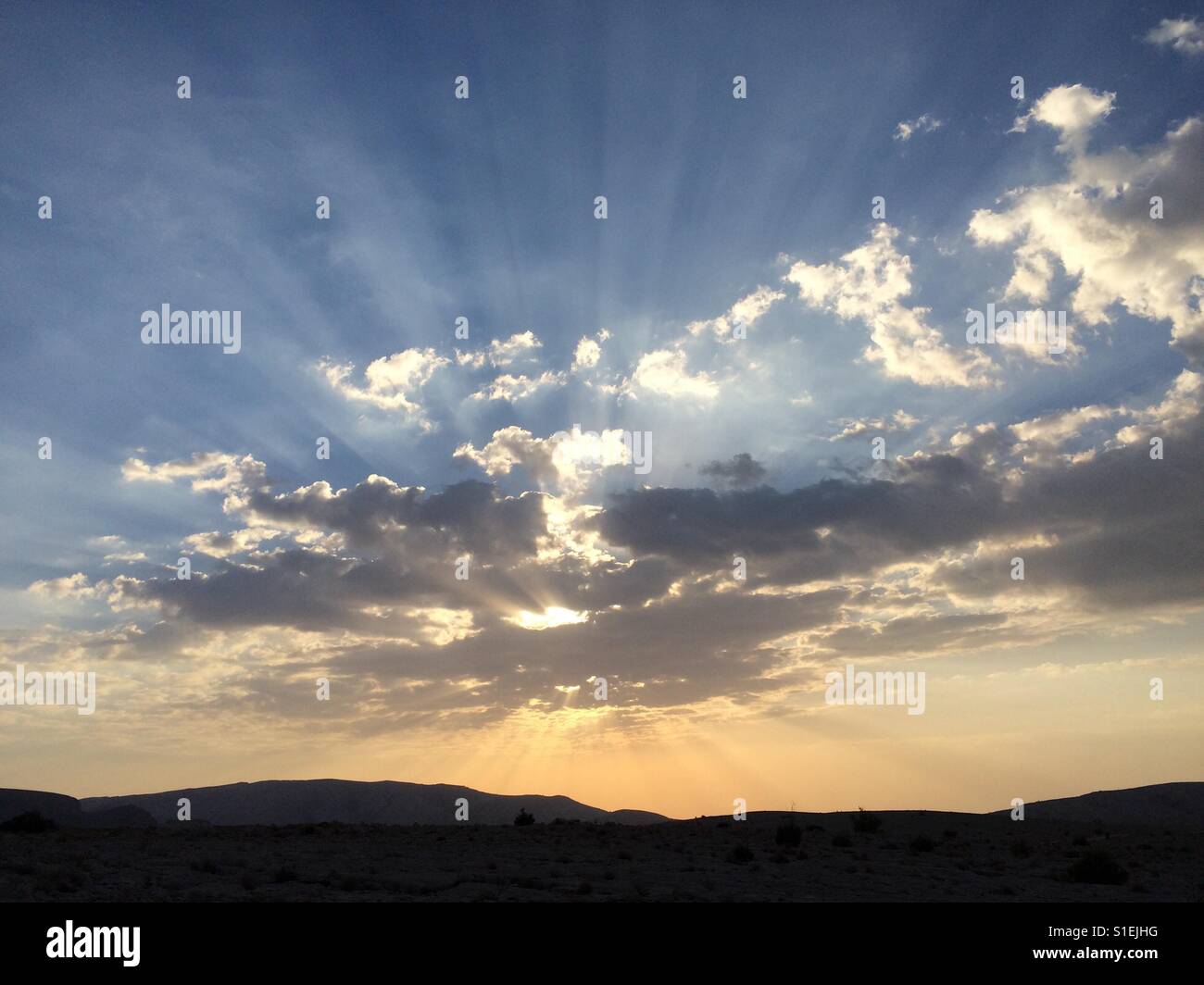 Sun rays burst through clouds in the Oman desert Stock Photo - Alamy