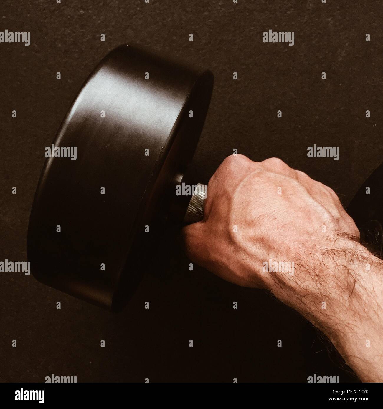 A close-up shot of a man's hand gripping a dumbbell weight Stock Photo ...