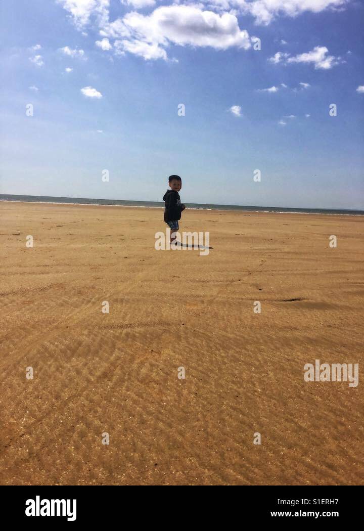 Lone boy on beach Stock Photo - Alamy