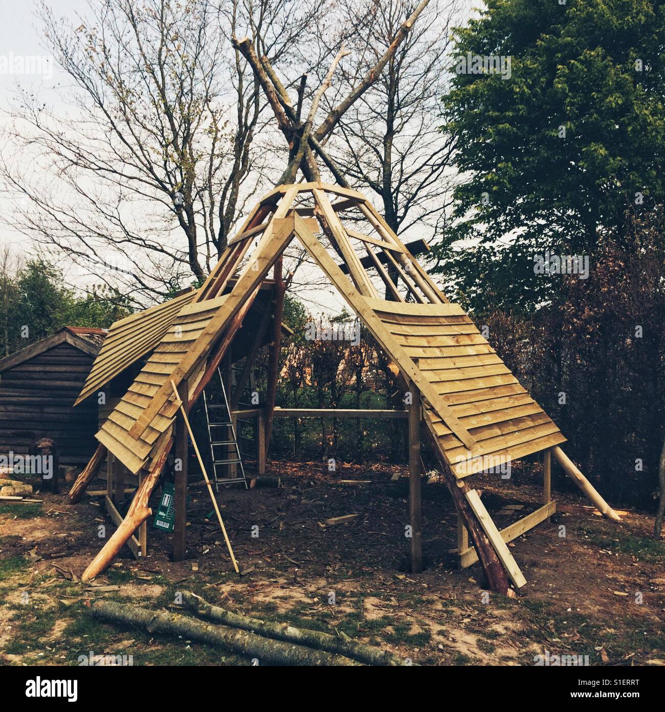 Wooden wigwam log cabin under construction Stock Photo - Alamy