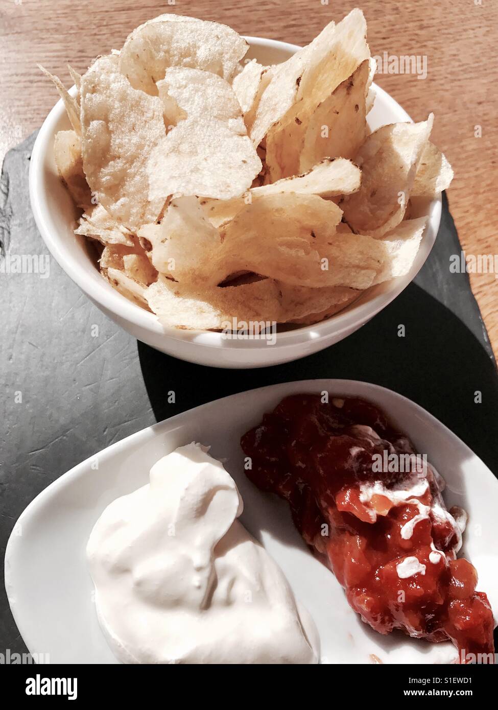 Crisps/chips with sour cream and jalapeño relish Stock Photo - Alamy