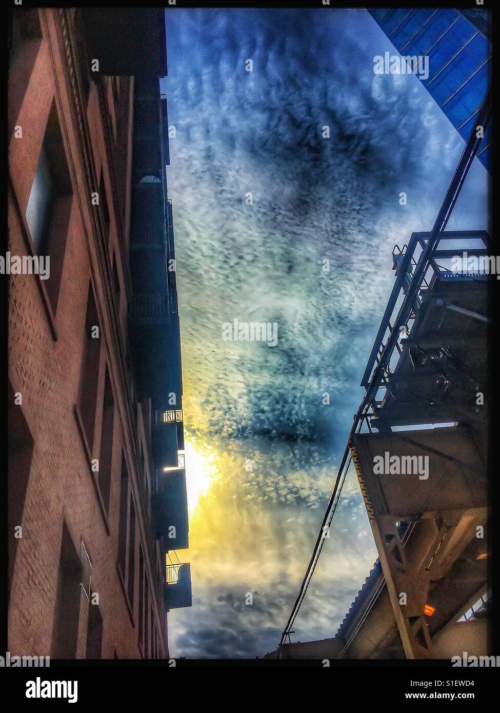 Chicago at sunset, looking up at balconies and elevated train platform ...