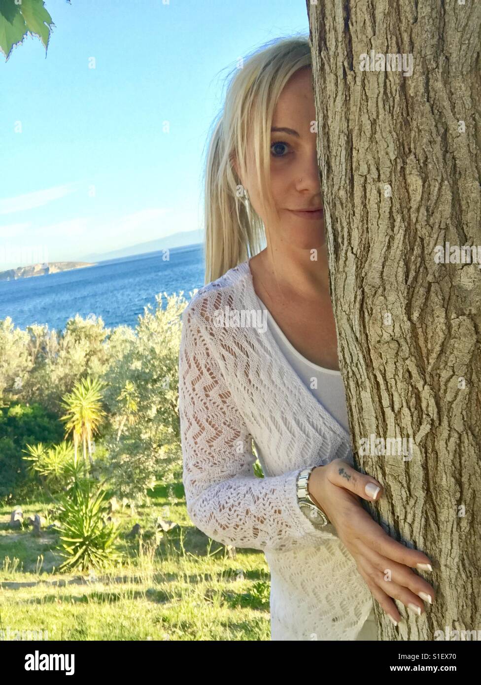 Woman behind a tree Stock Photo - Alamy