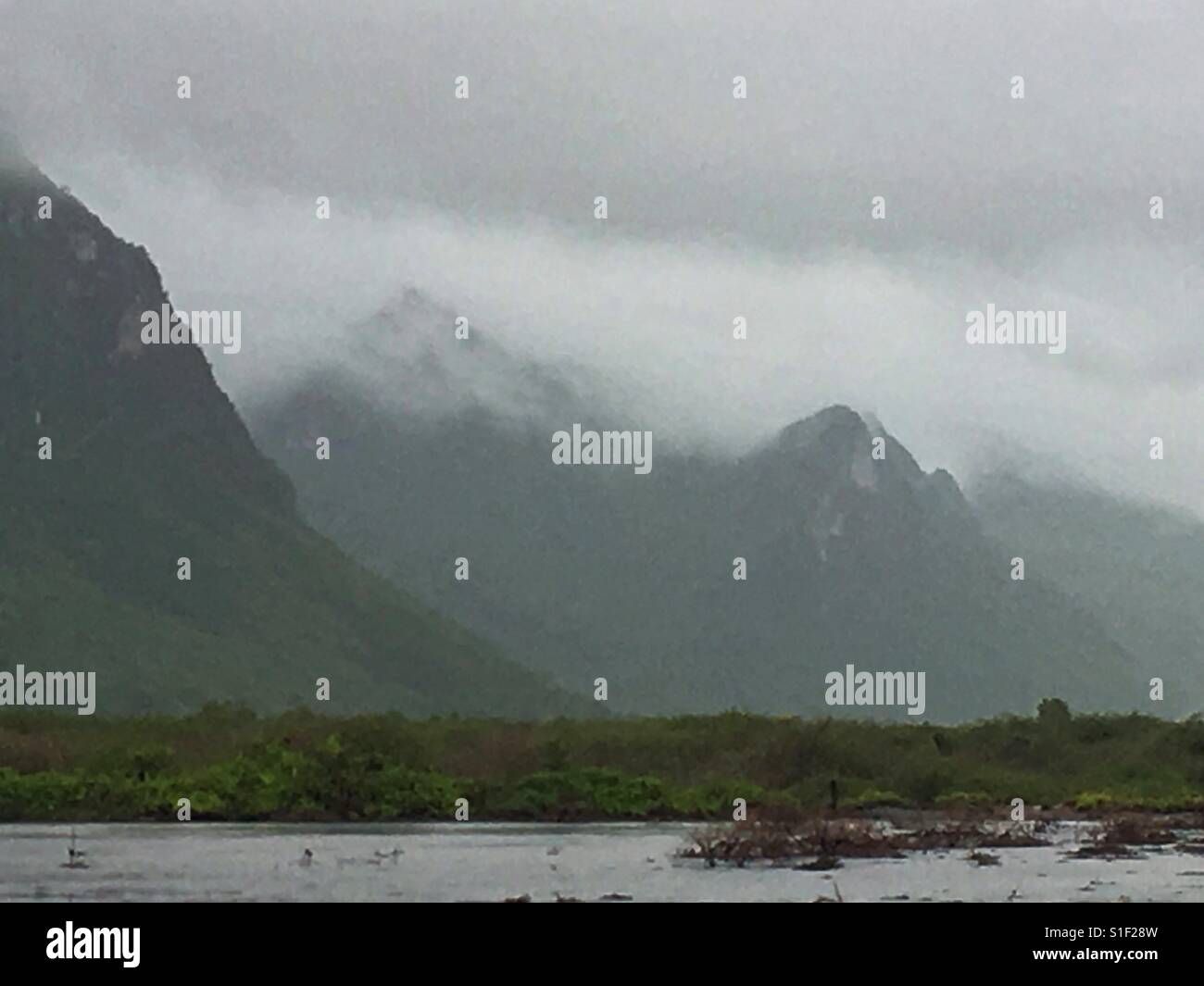 A misty mountain backgrounds a watery inlet Stock Photo - Alamy