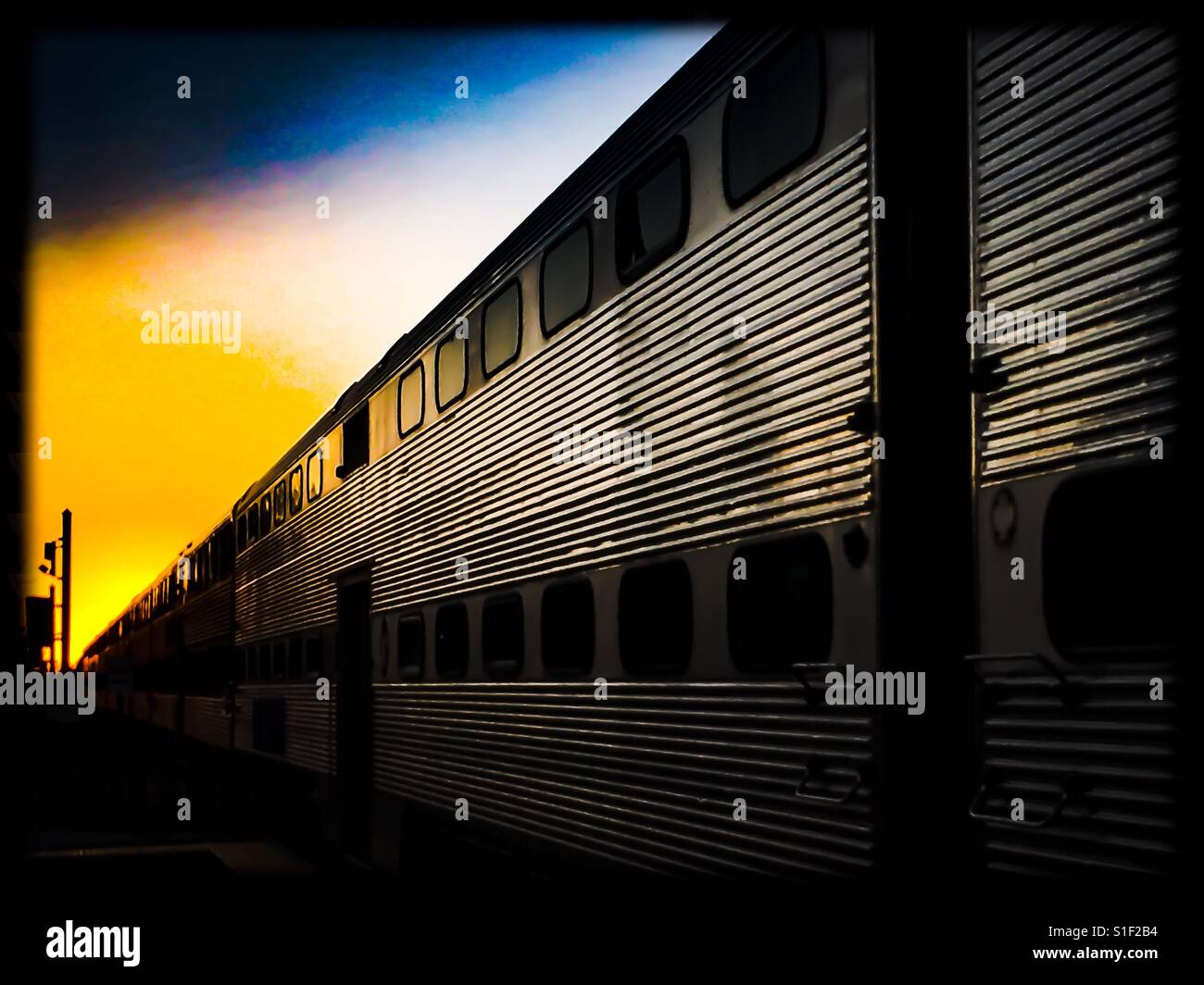 Commuter train riding into the sunset Stock Photo - Alamy