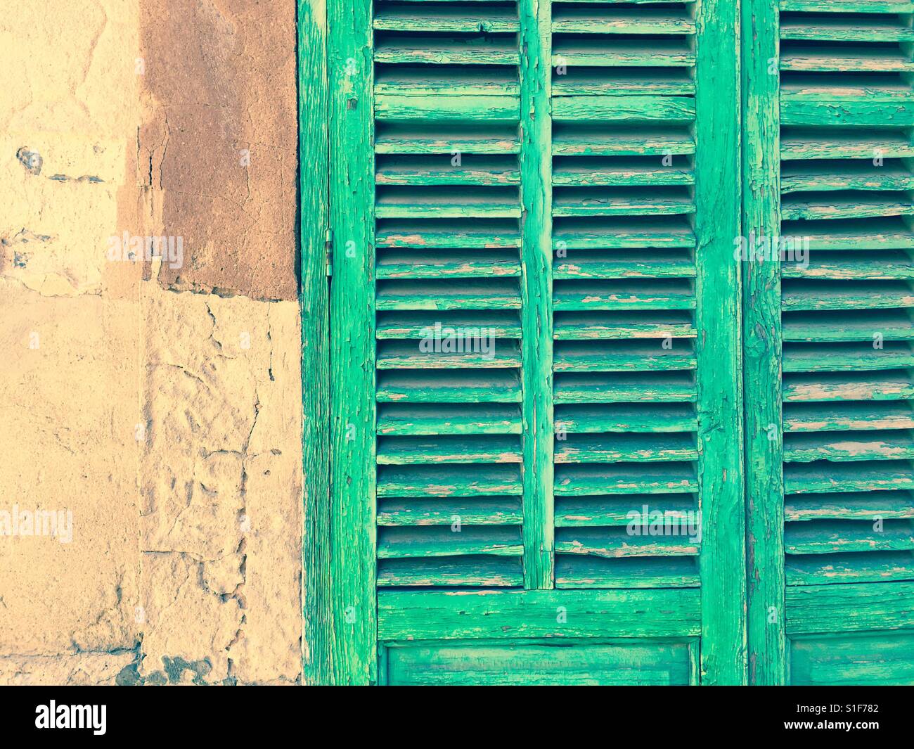 Green shutters with coffee and beige coloured wall Stock Photo - Alamy