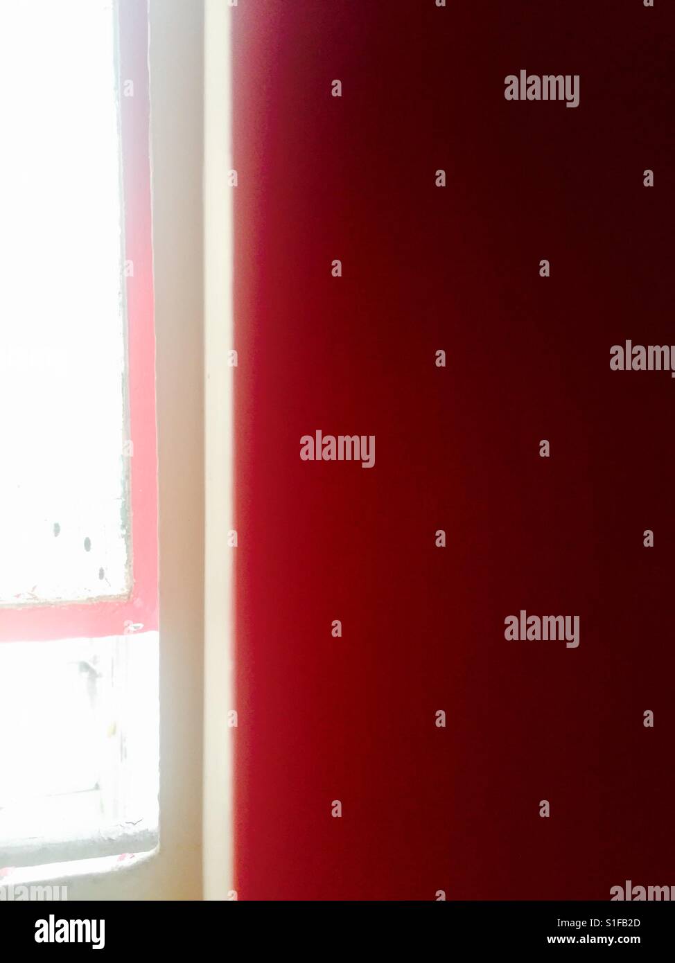 Window and red wall with white light through window on a rainy day ...