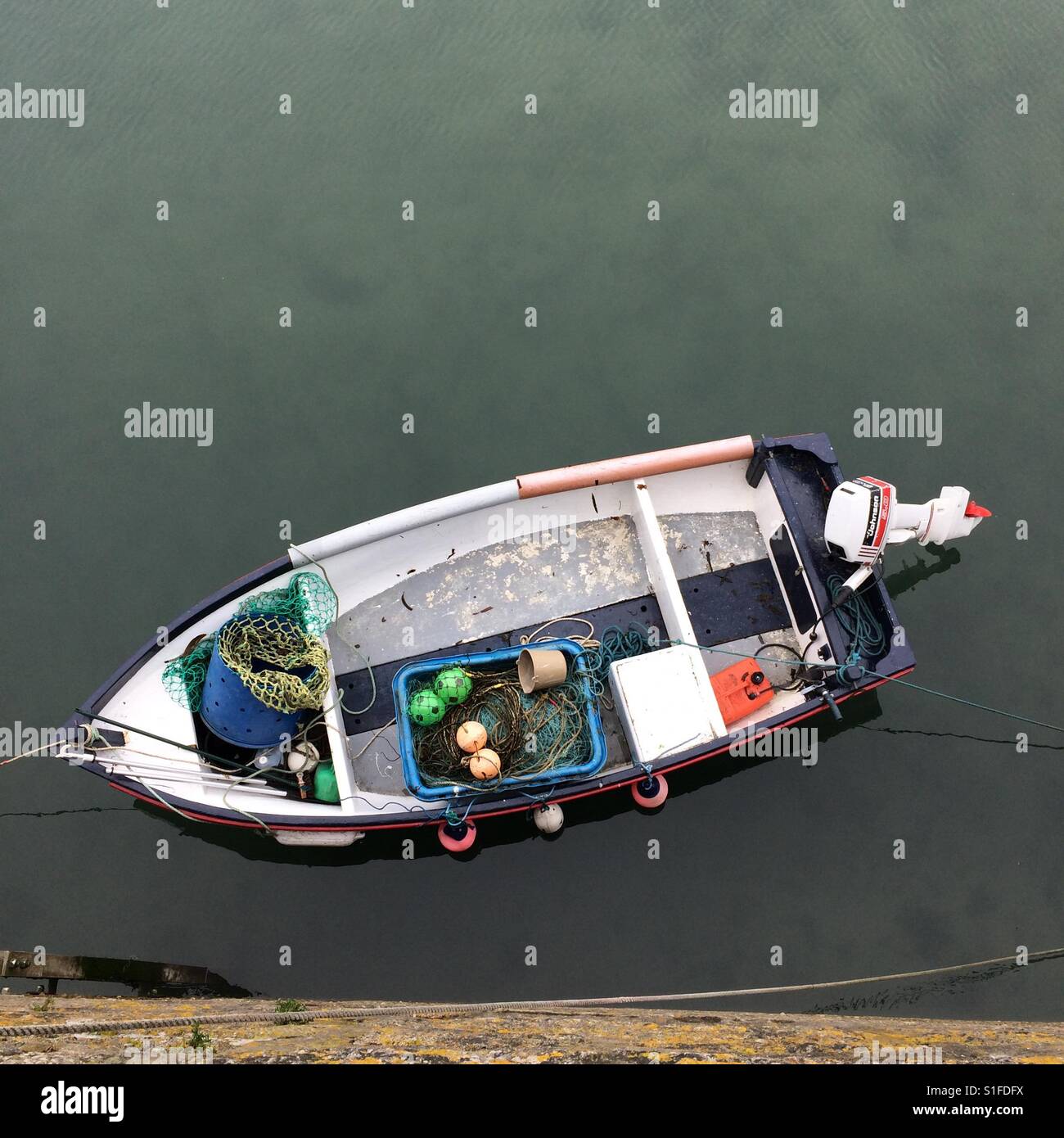 Top view of a small open inshore fishing boat by the quay at Mousehole ...