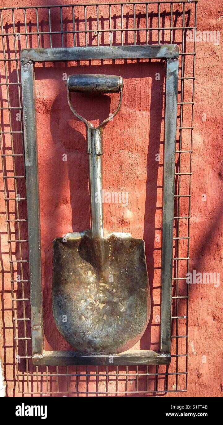 Hand spade against a wall for display Stock Photo - Alamy