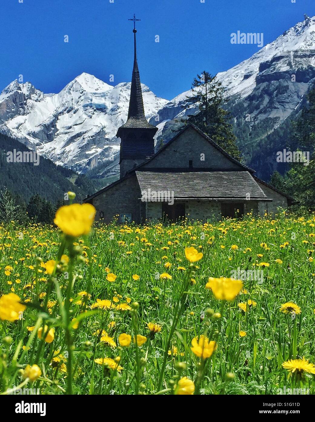 Historic church with backdrop of snowy mountains, Kandersteg ...
