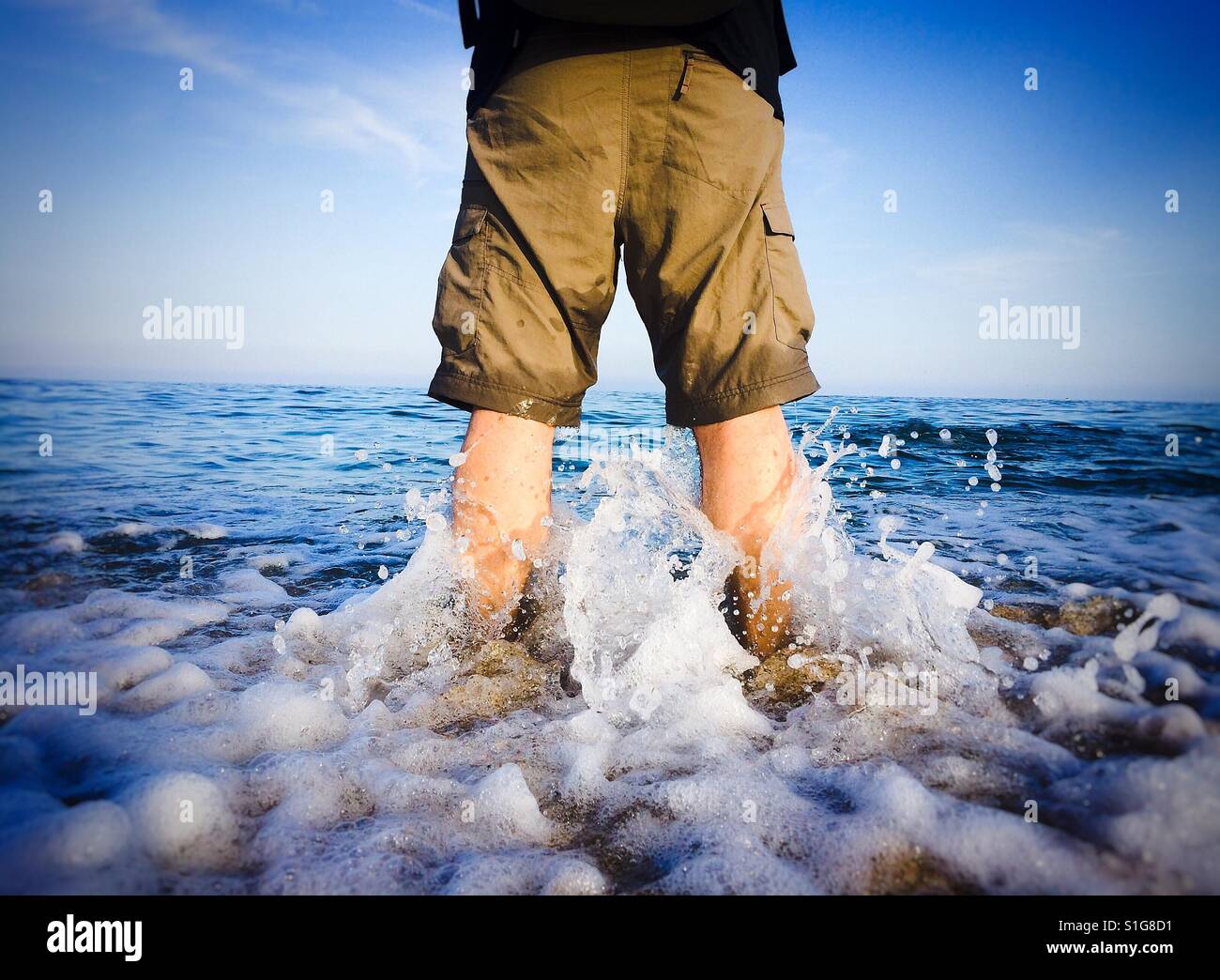 Man standing on the beach. Rear view Stock Photo - Alamy