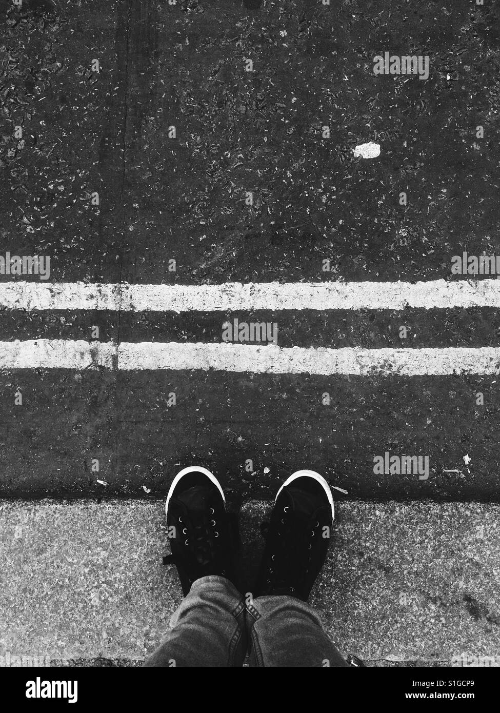 Man standing on pavement Stock Photo - Alamy