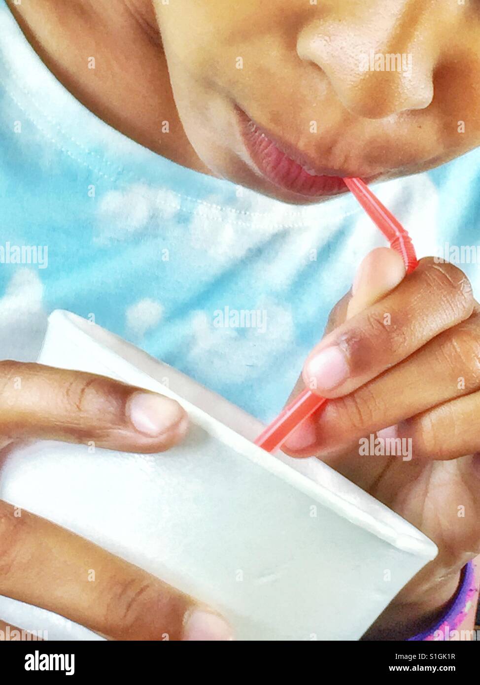 A child sucking a drink through a straw Stock Photo - Alamy