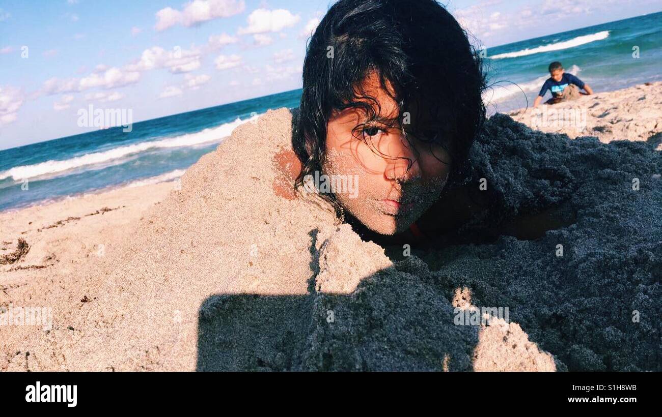 Girl buried in sand hi-res stock photography and images - Alamy