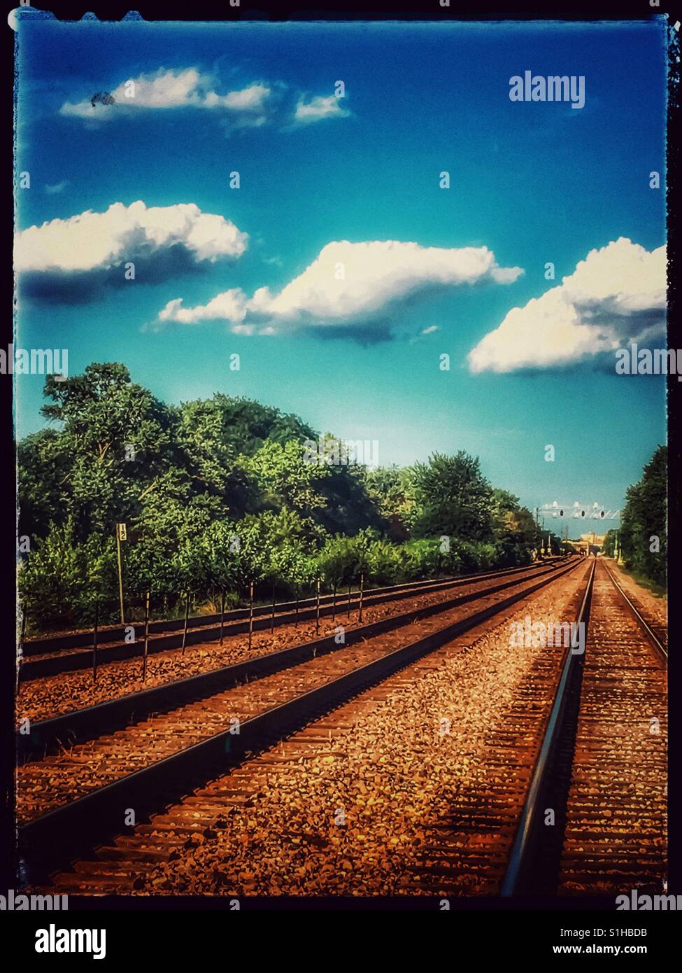 Triplets- Three clouds make their way across some railroad tracks Stock ...