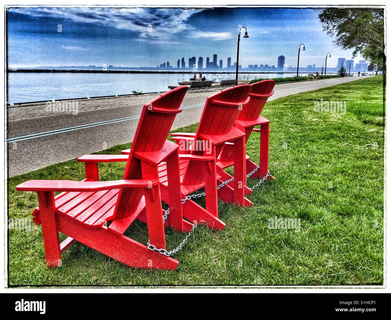 Three red Muskoka chairs in a row Stock Photo - Alamy