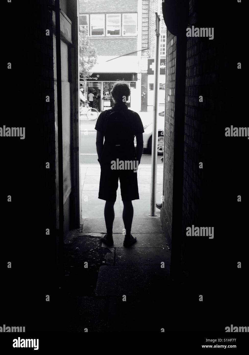 Man standing at end of an alleyway London Stock Photo - Alamy