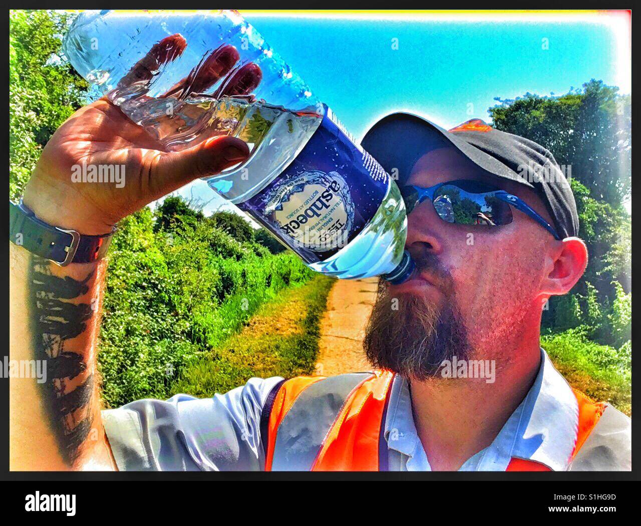 Postman drinking water from a bottle Stock Photo - Alamy