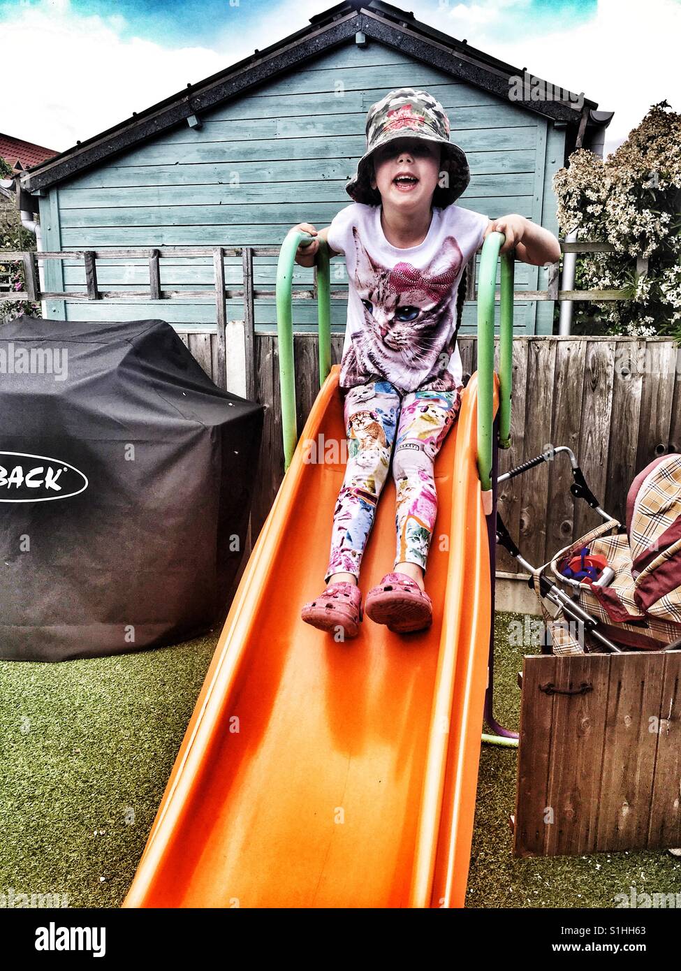 Child on slide in back garden Stock Photo - Alamy