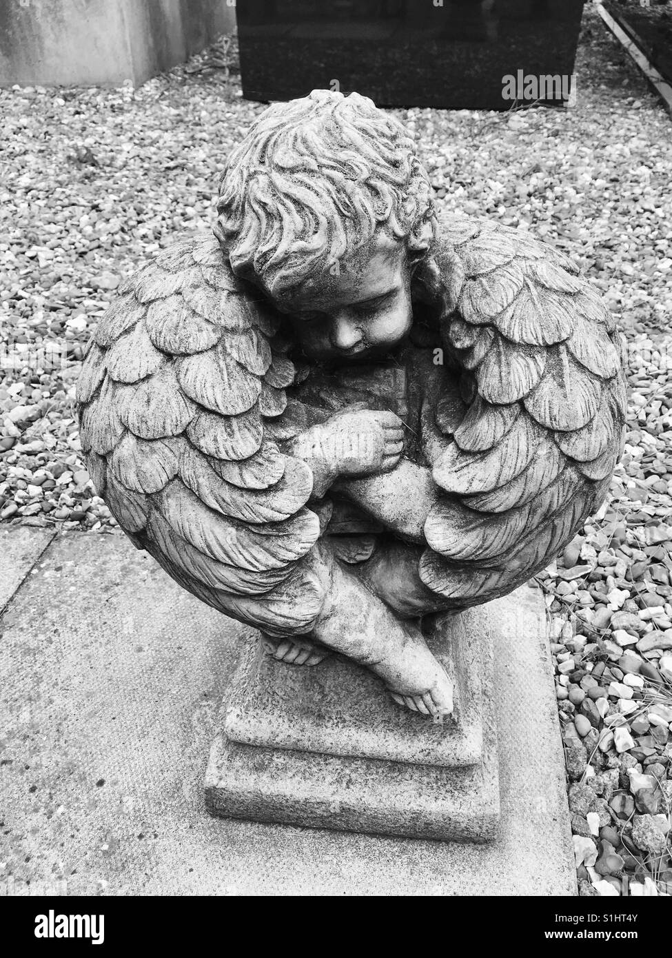 Stone angel Cupid statue memorial Stock Photo - Alamy