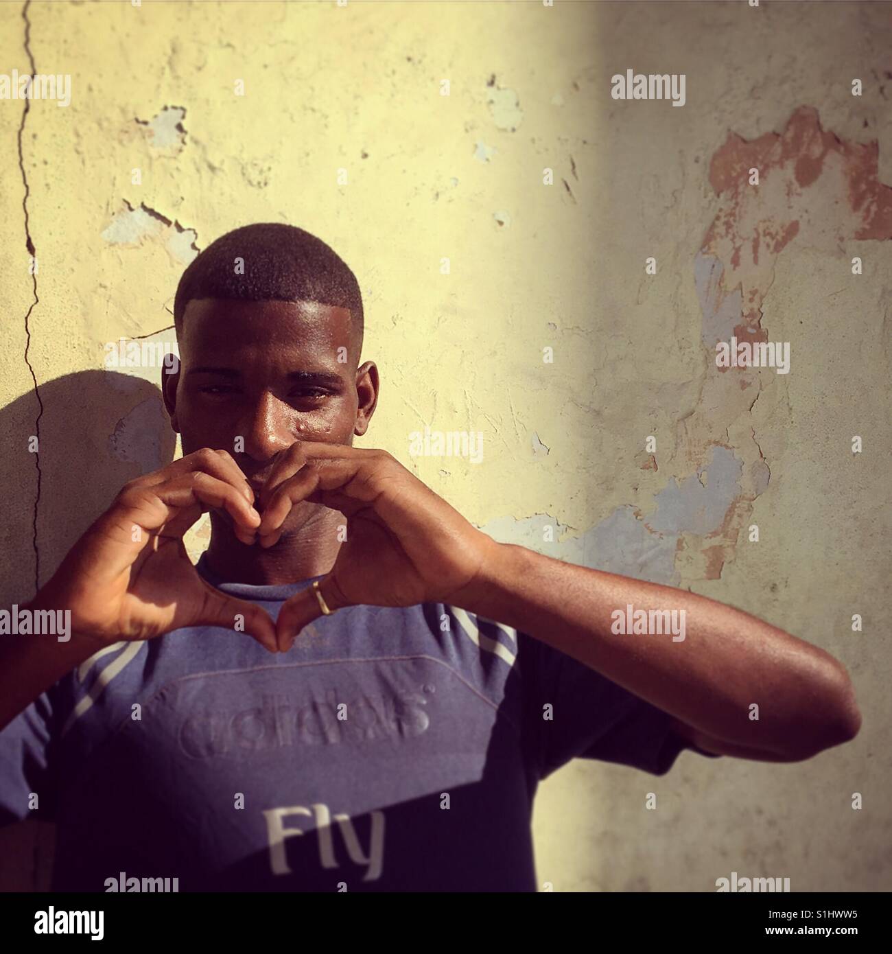 Young Cuban man making a heart shape with his hands Stock Photo - Alamy