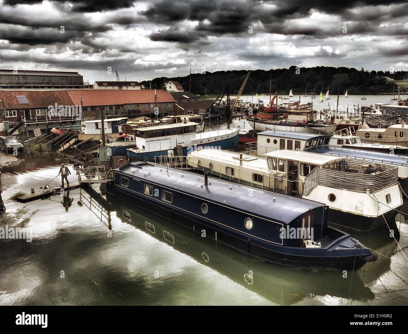 Houseboats and flooded walkway due to spring high tide, river Deben ...