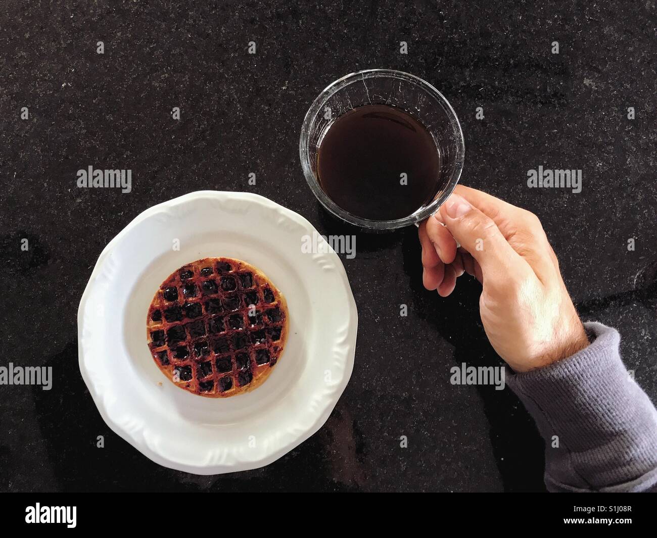 Ready to eat breakfast. Hand holding a coffee cup and a white plate ...