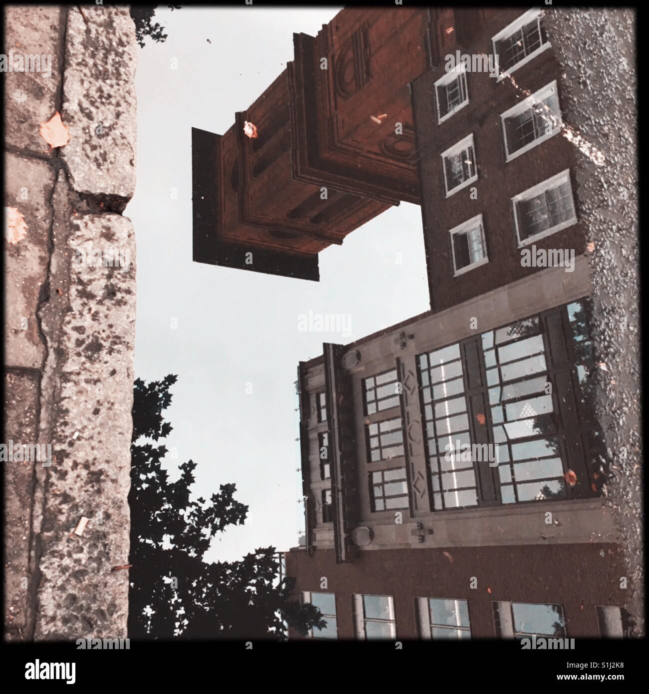 Reflection of building in a puddle Stock Photo - Alamy