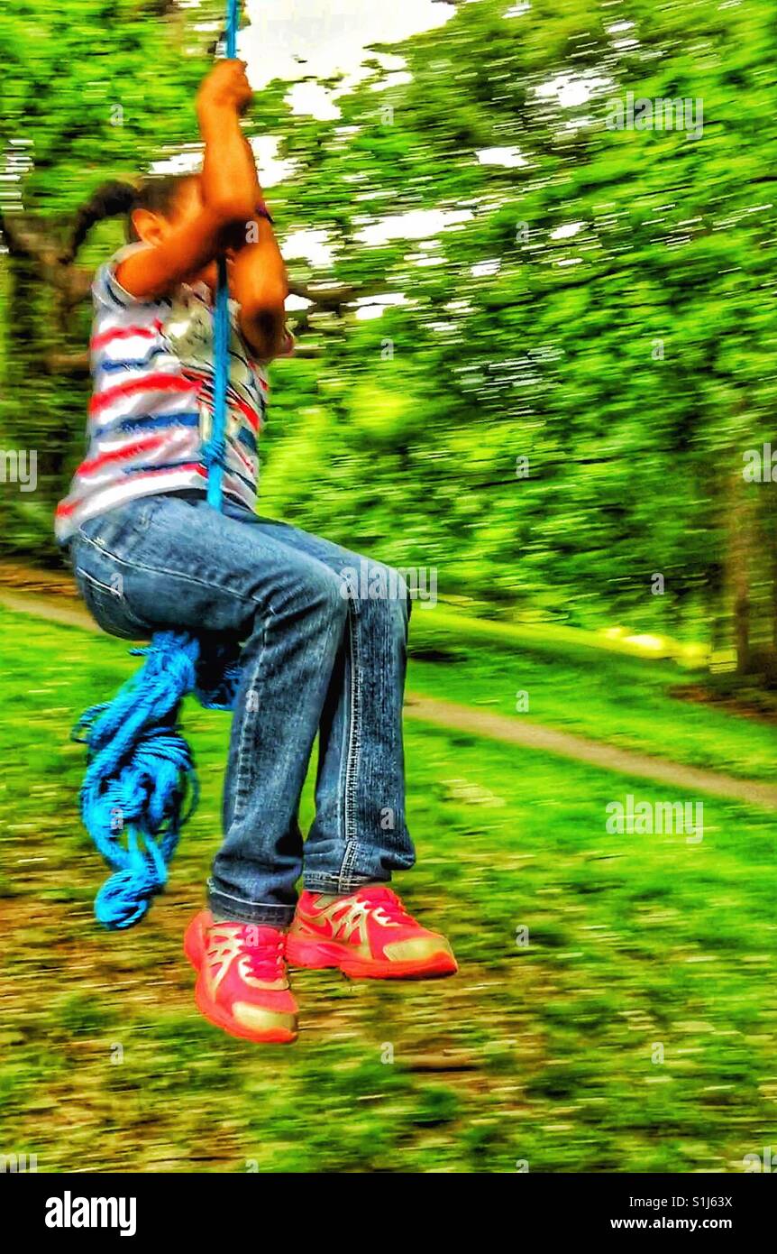 A young girl swings on a rope Stock Photo - Alamy