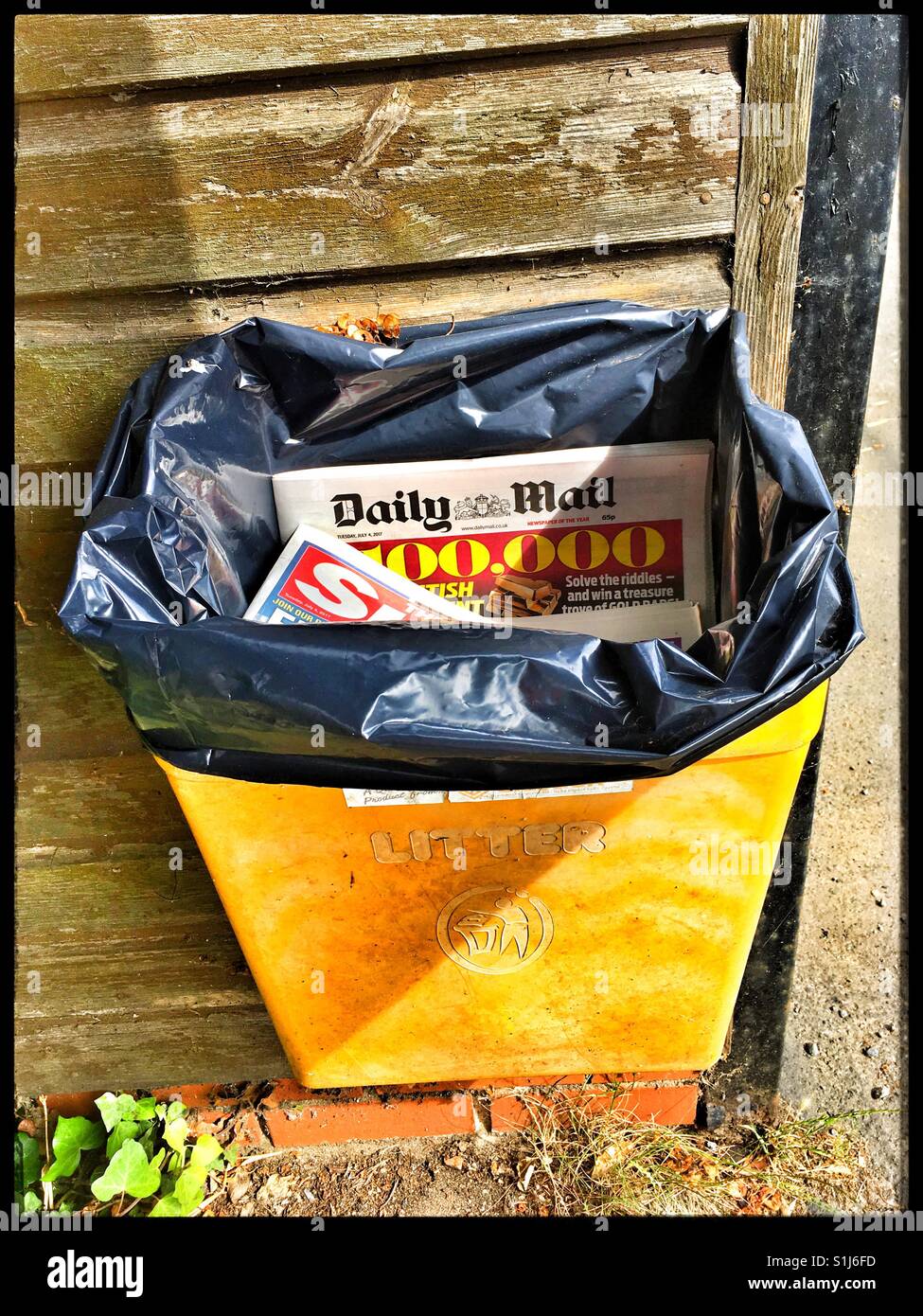 Tabloids dumped into a public bin Stock Photo - Alamy