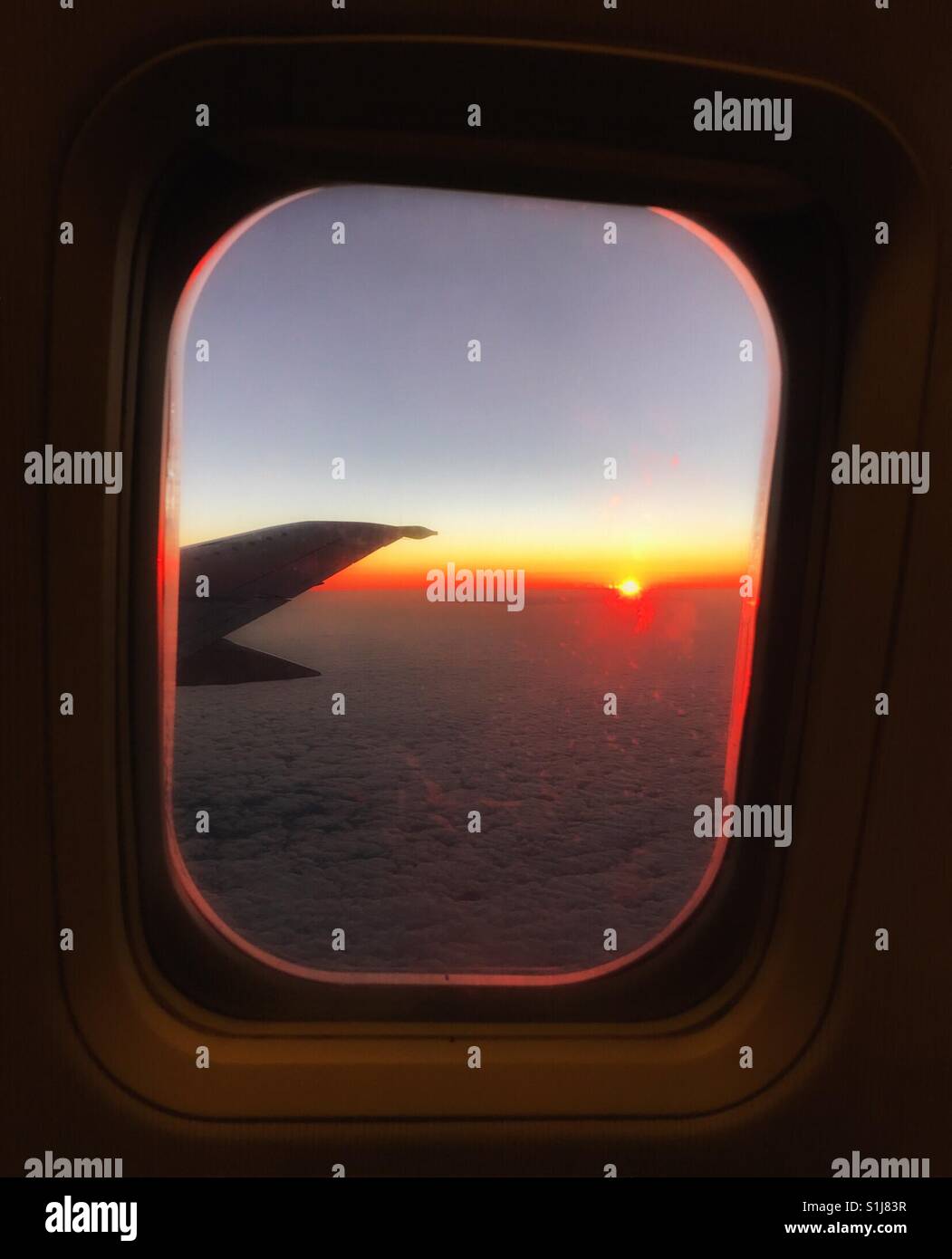 Sunrise through the window of an airplane in flight Stock Photo - Alamy