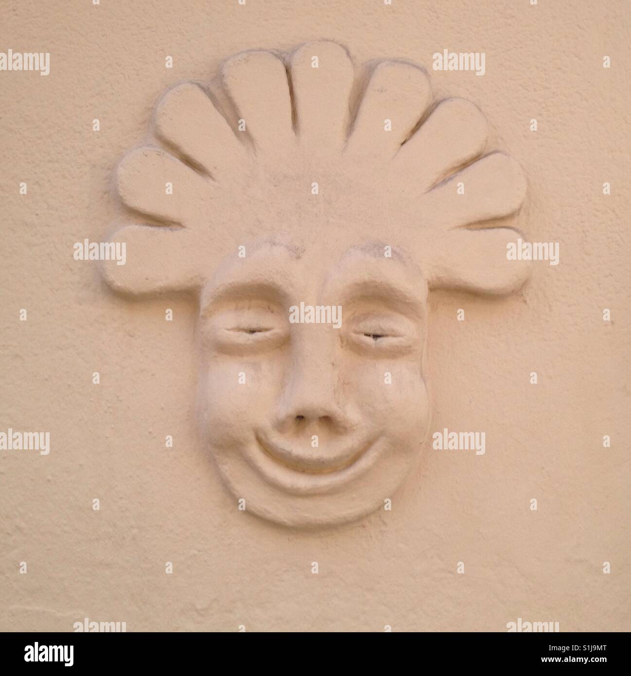 Sculpture of face on a wall Stock Photo - Alamy