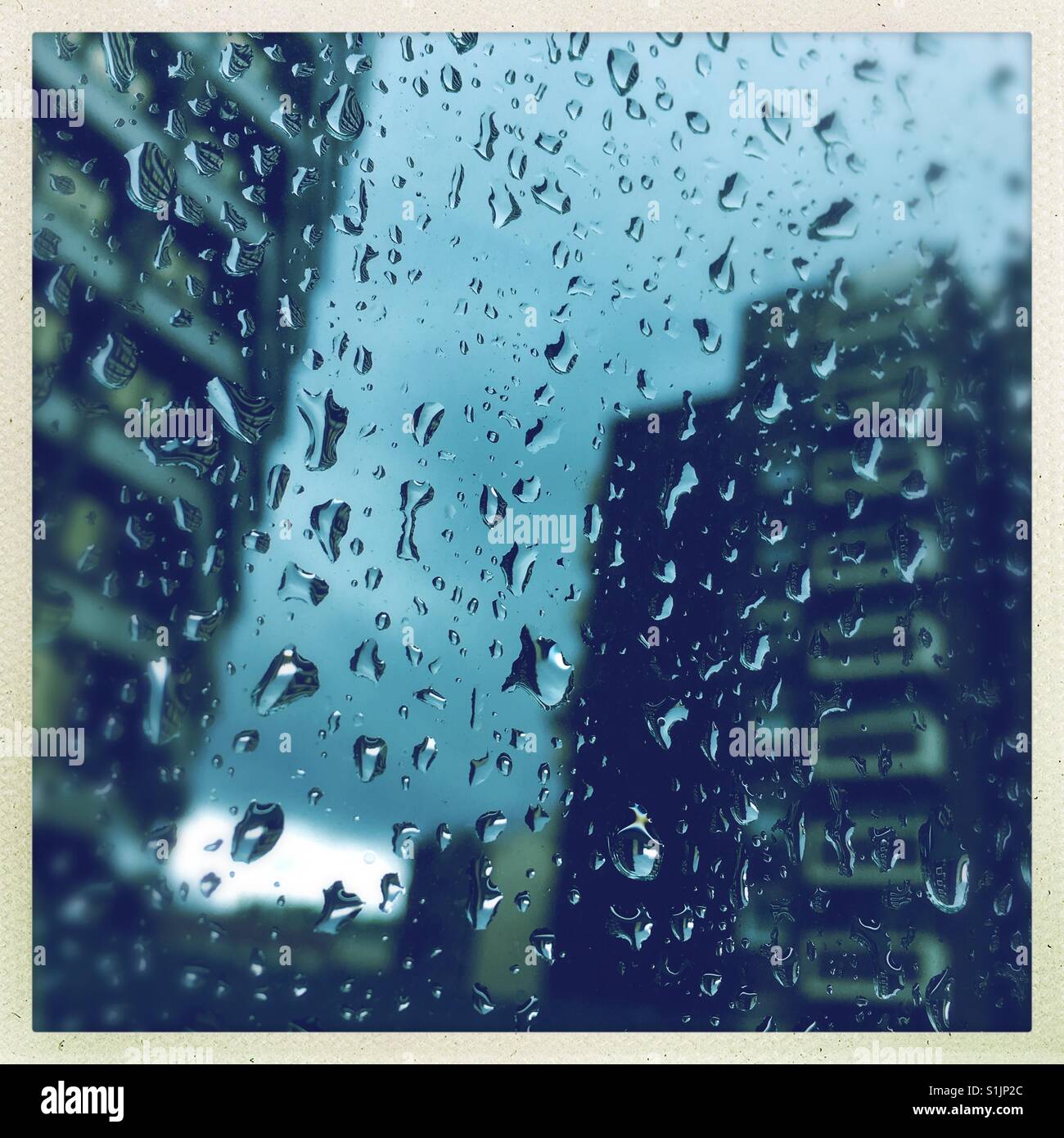 Raindrops on a window with buildings in the background Stock Photo - Alamy