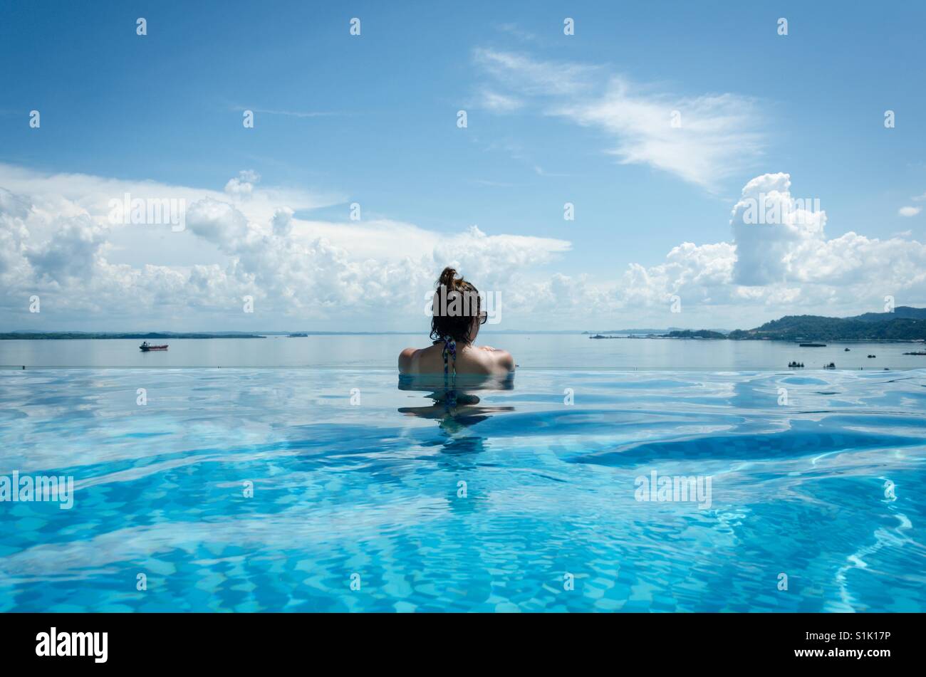 Woman overlooking pool hi-res stock photography and images - Alamy
