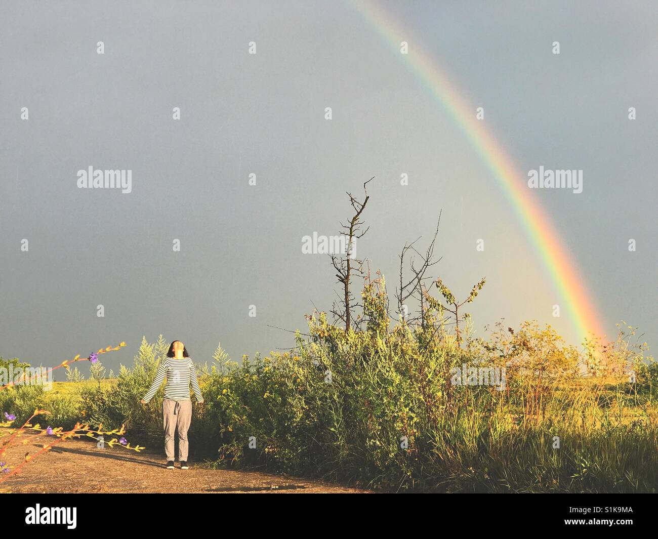 Woman standing under a rainbow Stock Photo - Alamy