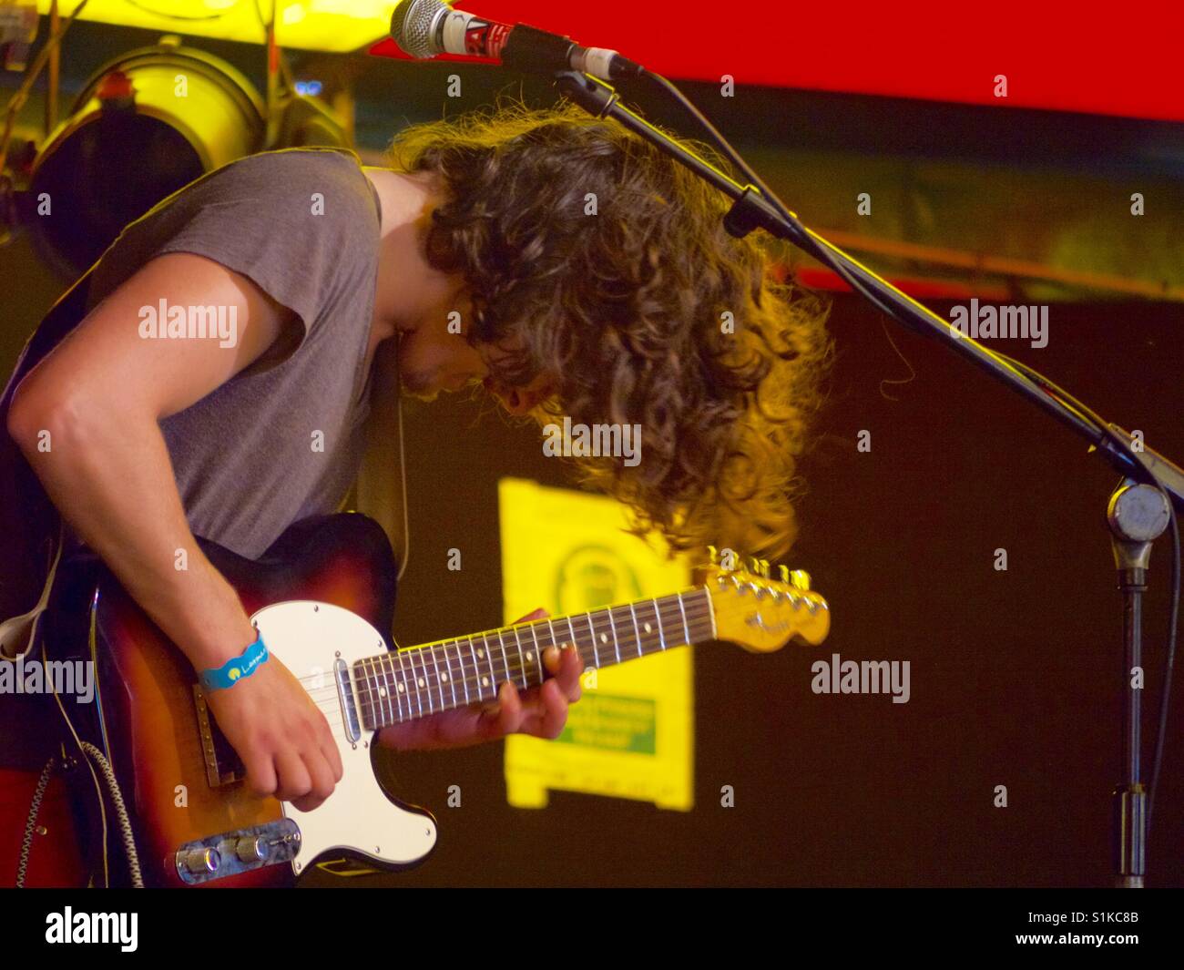 Musician head banging while playing guitar Stock Photo - Alamy