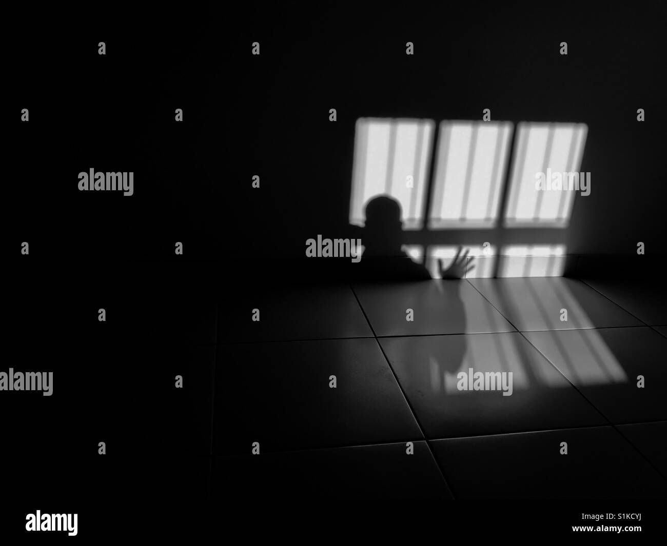 Man's shadow by the window projected on the ground Stock Photo - Alamy