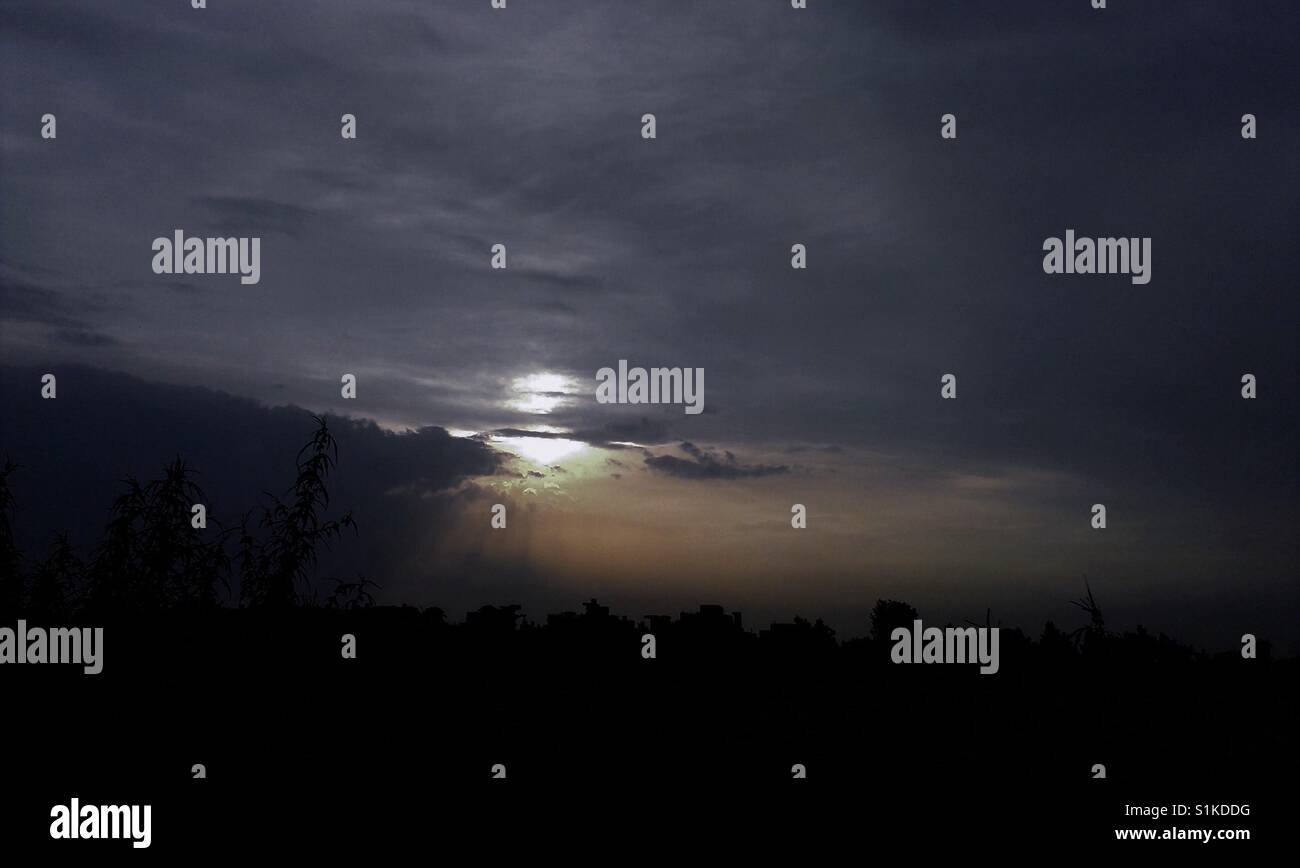 Sun coming out of clouds Stock Photo - Alamy