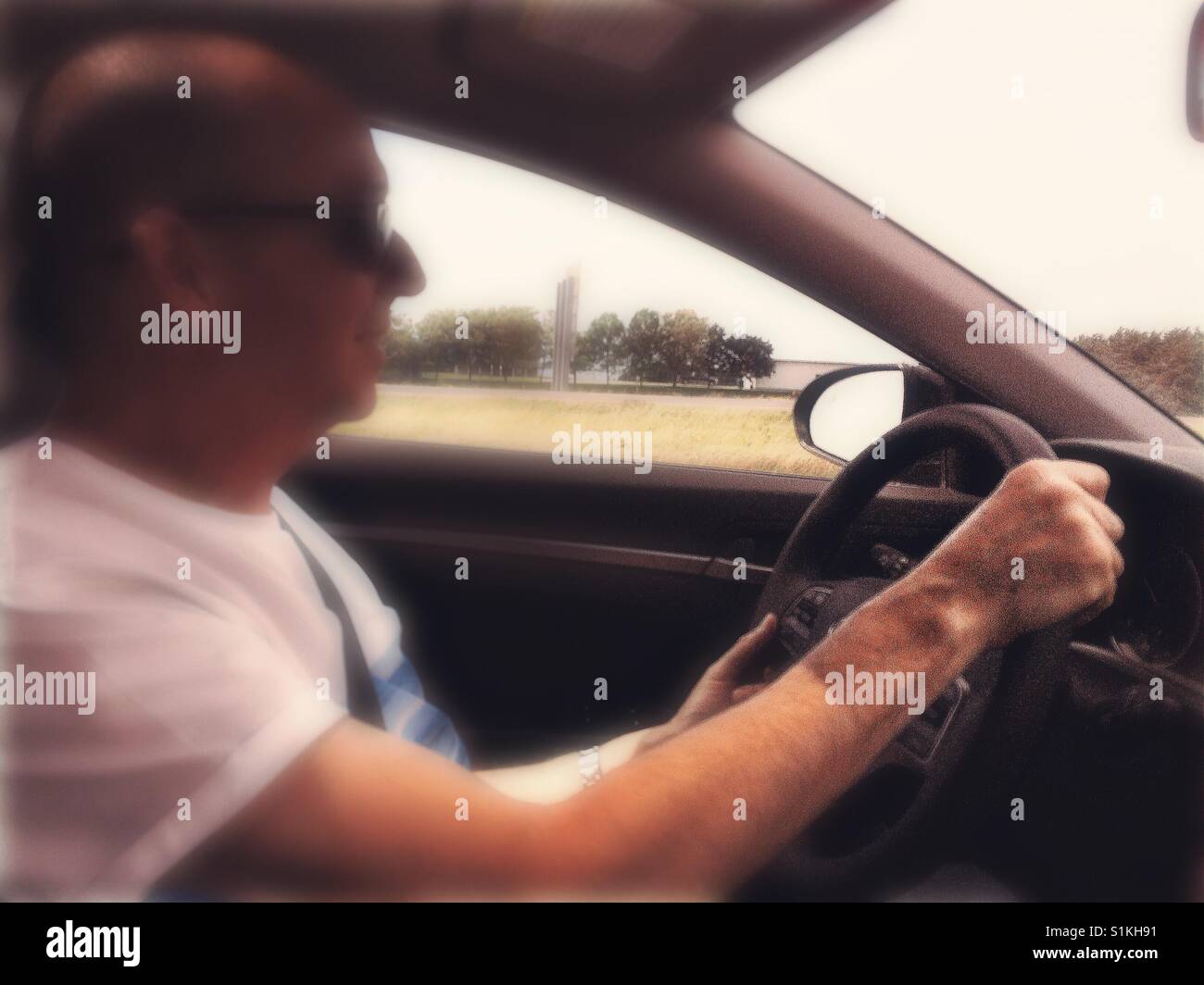 Middle aged man driving left hand drive car, Canada Stock Photo - Alamy