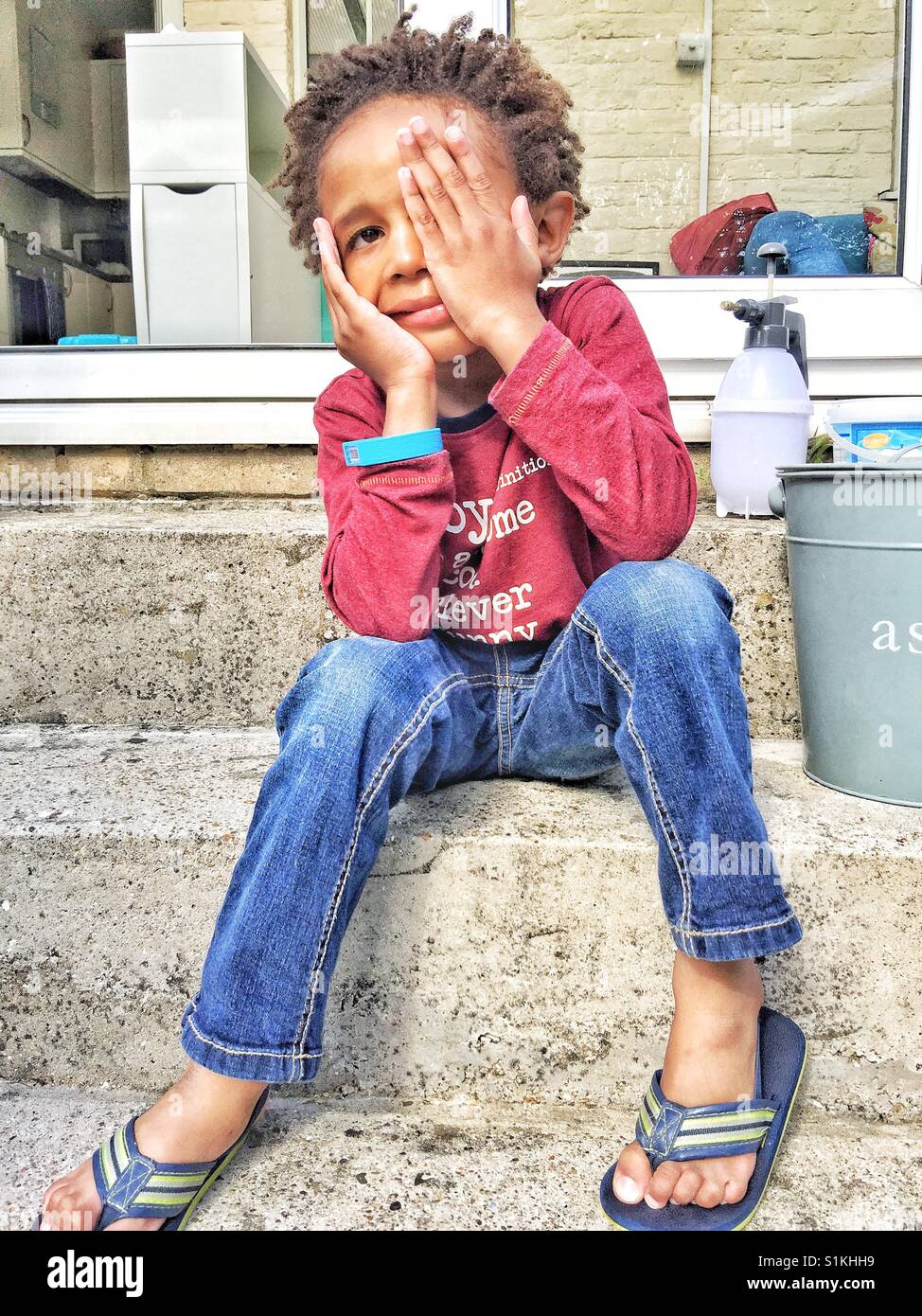 The little boy hiding part of his face Stock Photo - Alamy