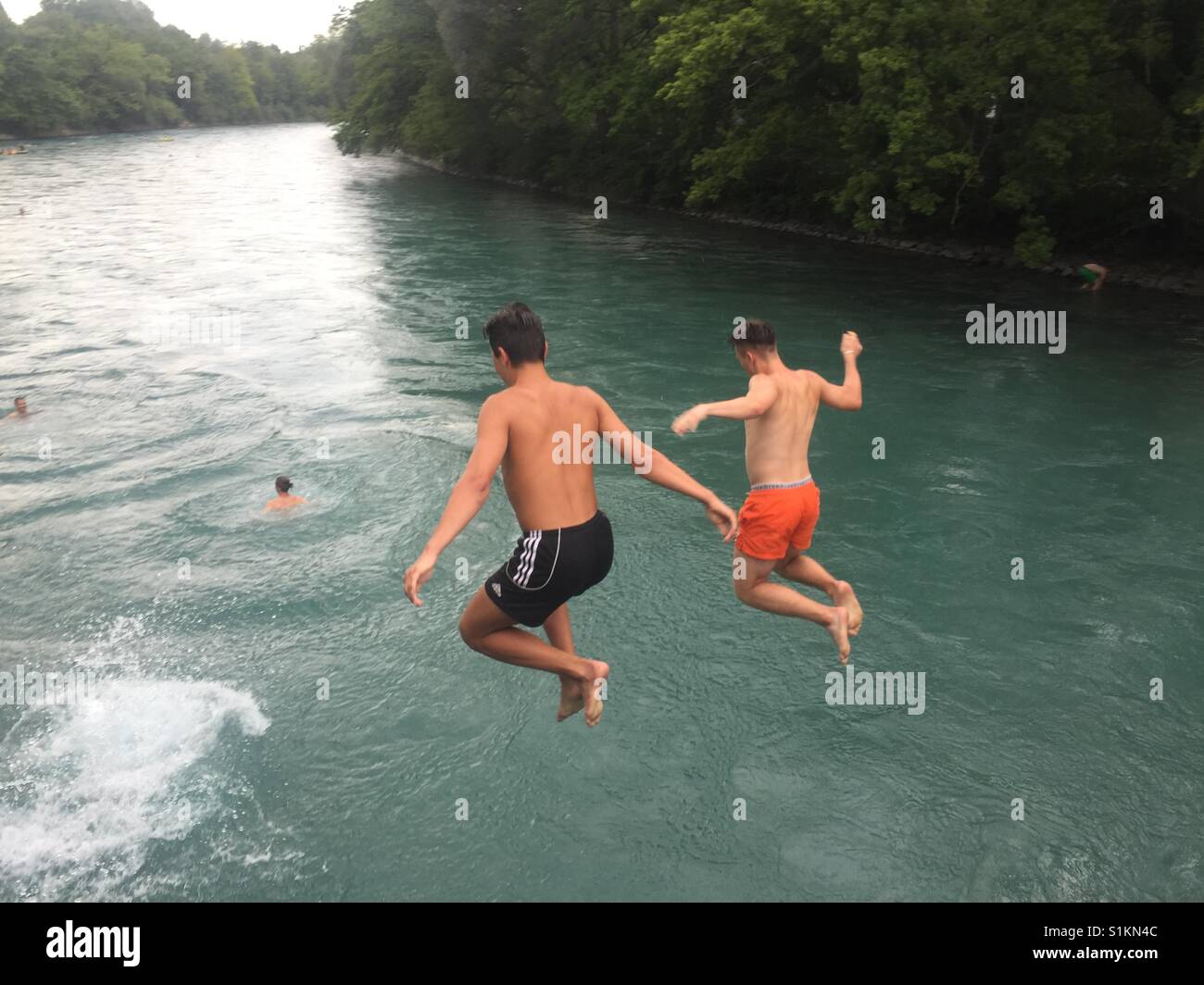 Two boys take a leap into the fast-flowing river Aare in Bern ...