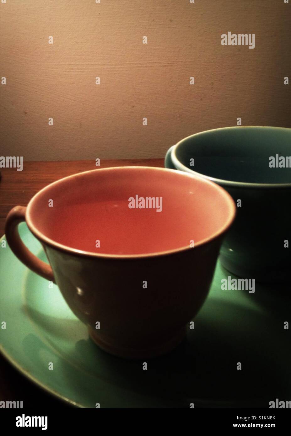 Tea cups on dinner plate Stock Photo - Alamy