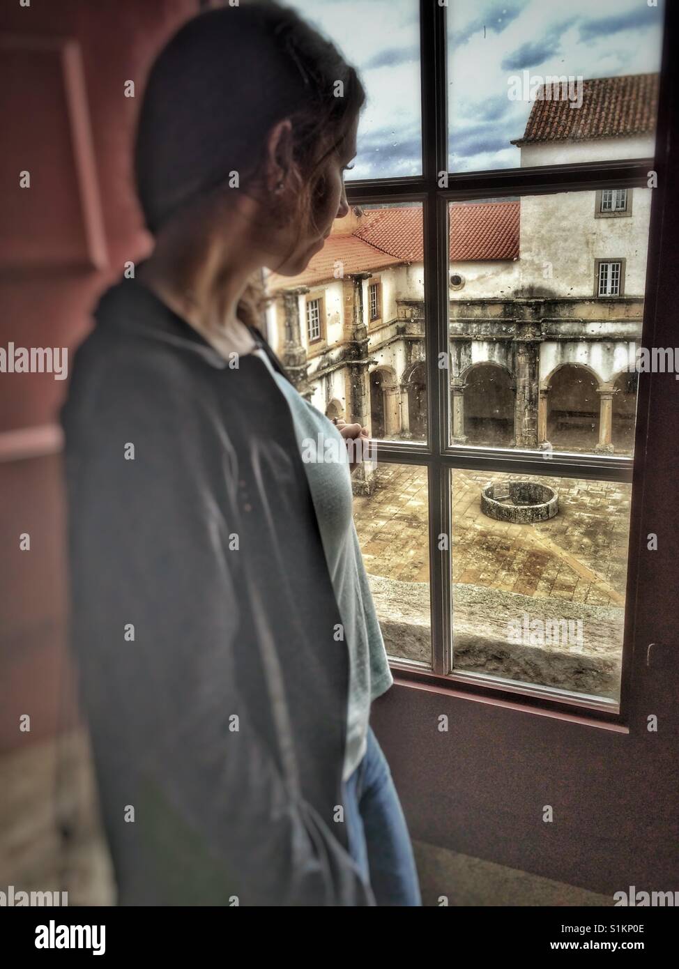 Pensive woman looking out a window from a castle in Portugal Stock ...