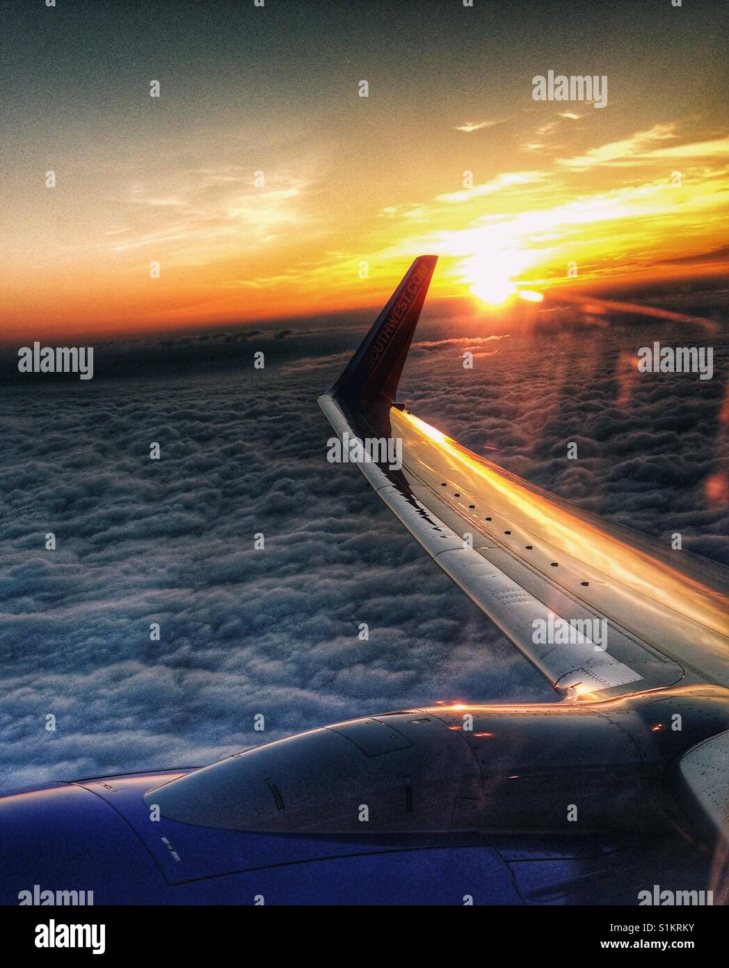 View from airplane window of the sunset and plane wing Stock Photo - Alamy
