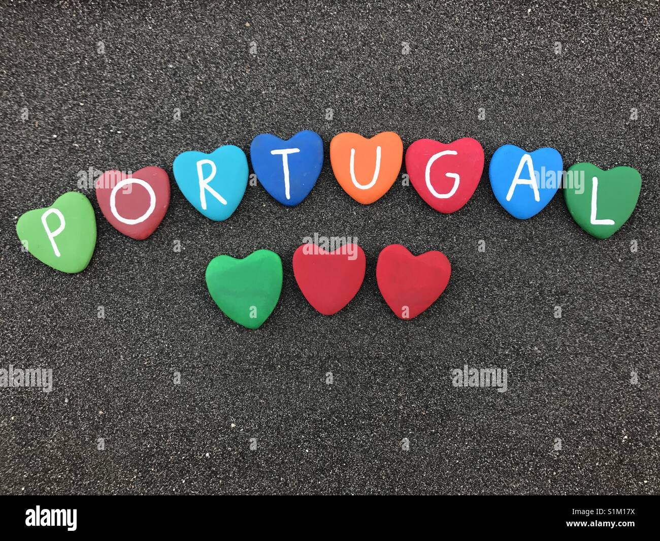 Portugal country name with colored heart stones over black volcanic ...