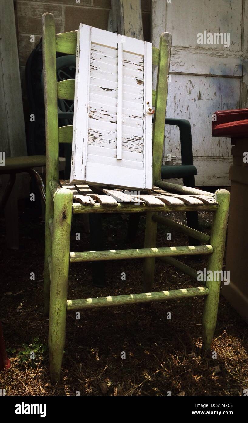 Old green chair and white shutter for sale Stock Photo - Alamy