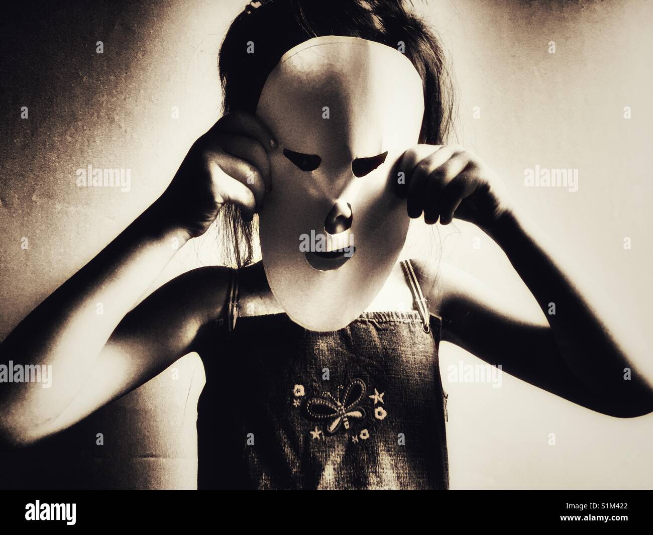Girl with mask covering her face Stock Photo - Alamy