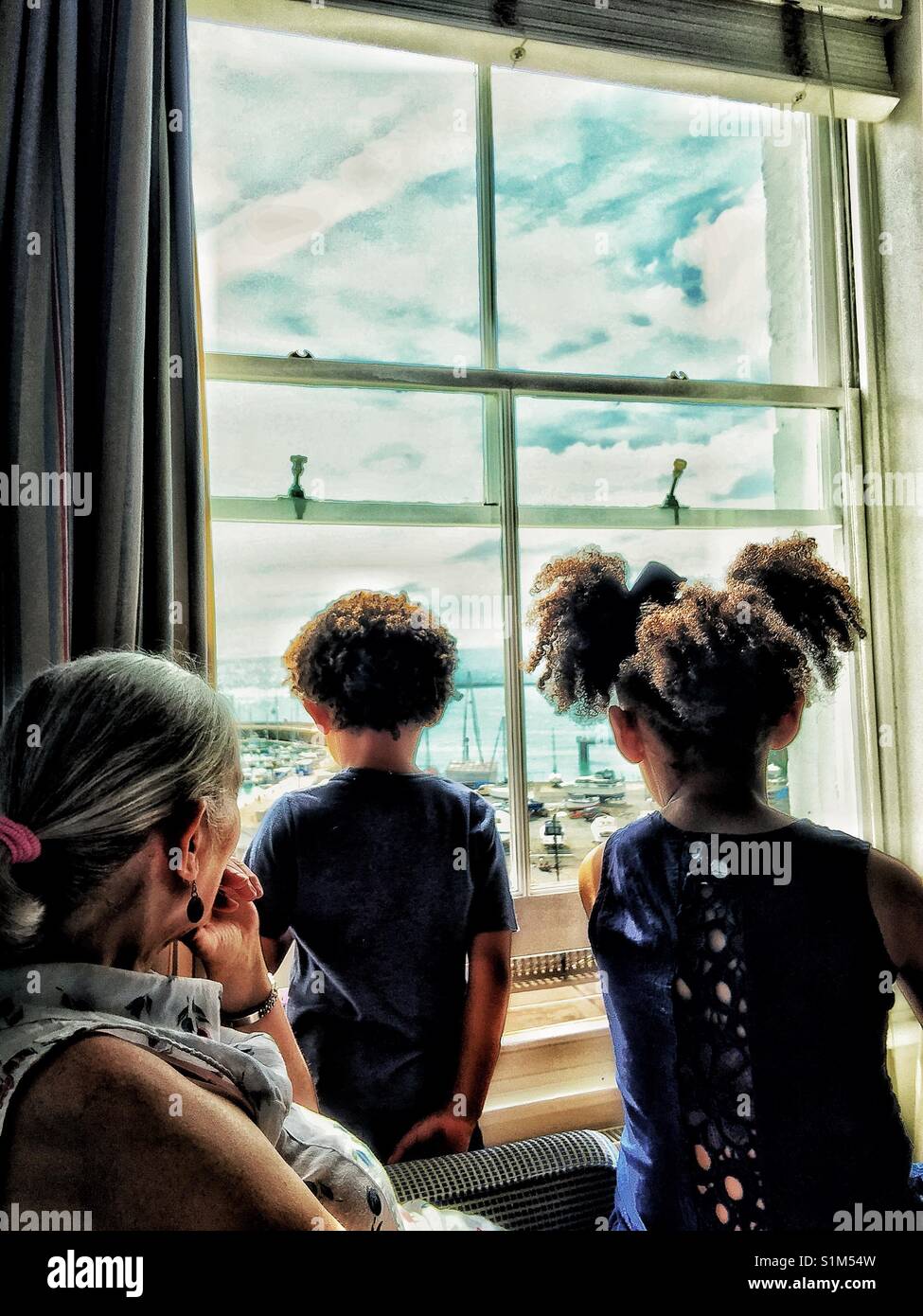 Family looking through a window Stock Photo - Alamy