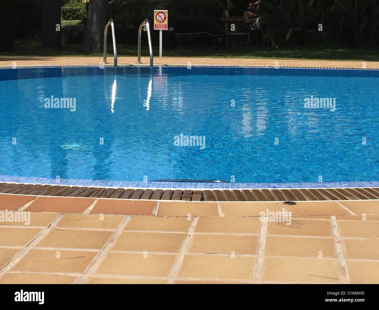 Swimming pool with terracotta tiles around edge Stock Photo - Alamy